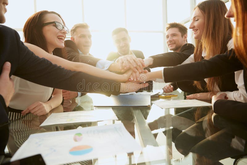 Group of Young Business People Joining Their Palms Over a Work Desk ...