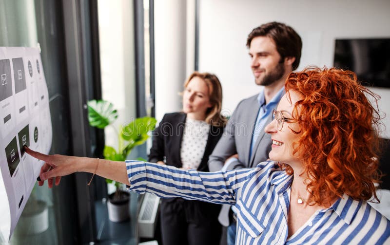 A Group of Young Business People in an Office, Brainstorming. Stock ...