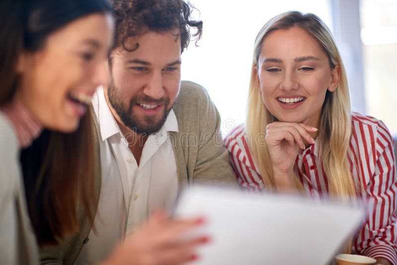A Group of Young Business People Reading Documents at a Meeting. People ...