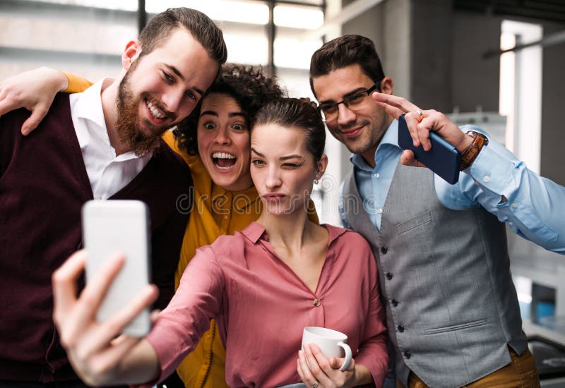 A Group of Young Businesspeople with Smartphone in Office, Taking ...