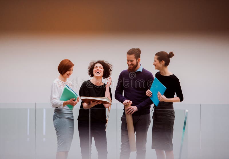 Group of Young Businesspeople Standing in Office Building, Talking ...