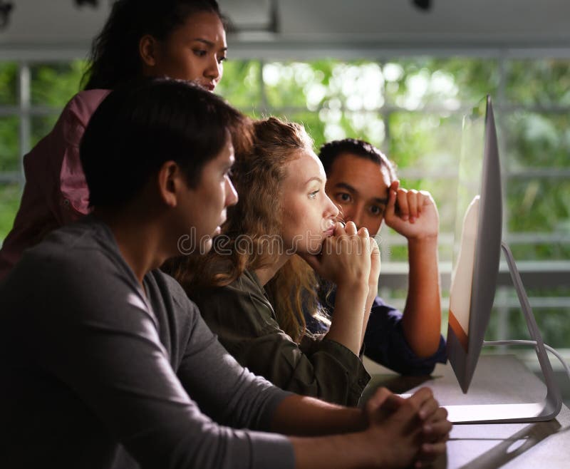 Group of Young Businesspersons Looking Intently at the Screen Stock ...