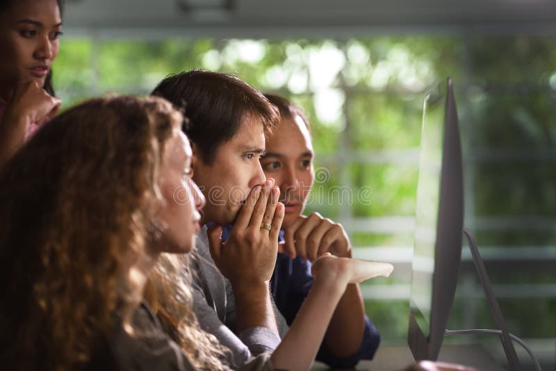 Group of Young Businesspersons Looking Intently at the Screen Stock ...