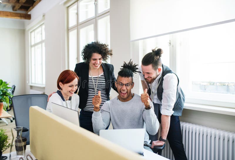 Group of Young Cheerful Businesspeople Using Laptop in Office, Start-up ...