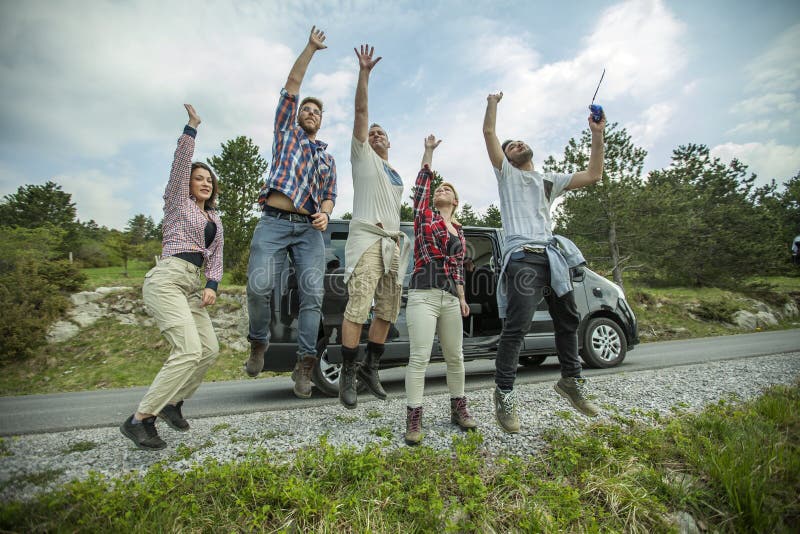Group of Young Cheerful Friends Jumping Having Fun Outdoors on the Road ...
