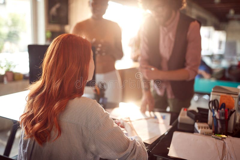 Group of Young Colleagues Looking Project Documents at Office ...