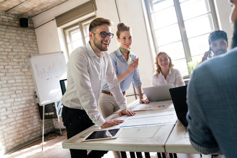 Group of Young Confident Happy Business People Analyzing Data during ...