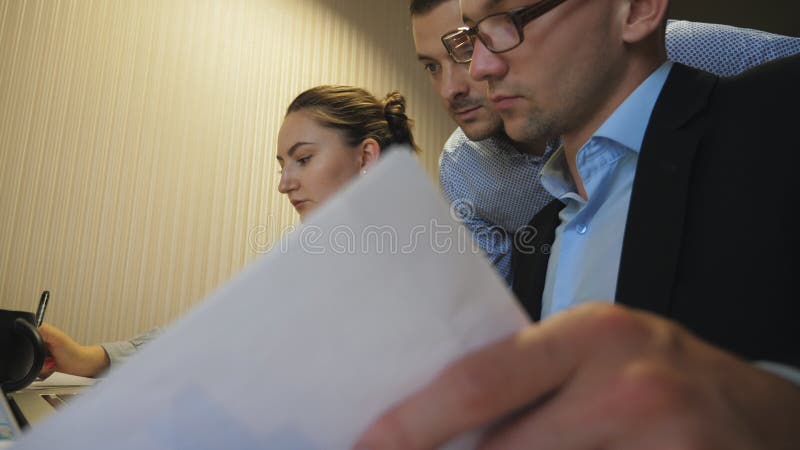 Group of Young Coworkers Comparing Sales Result Graph on Paper with ...
