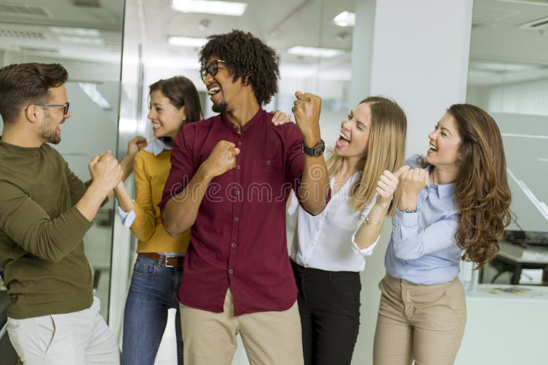 Group of Young Excited Business People with Hands Up Standing in Office ... Group of Young Excited Business People with Hands Up Standing in Office ...