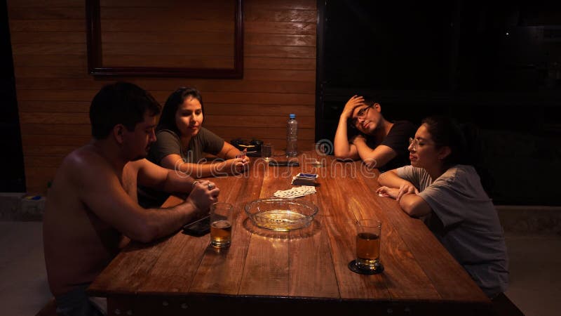 Group of Young Friends Drinking, Talking, and Playing Cards on a Cabin ...