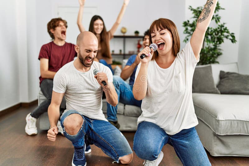 Group of Young Friends Having Party Singing Song Using Microphone at ...