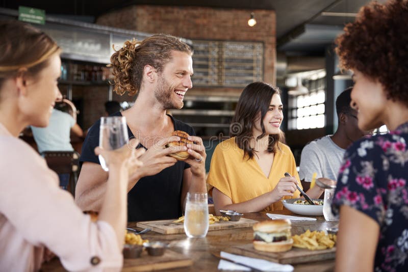Group of Young Friends Meeting for Drinks and Food in Restaurant Stock ...