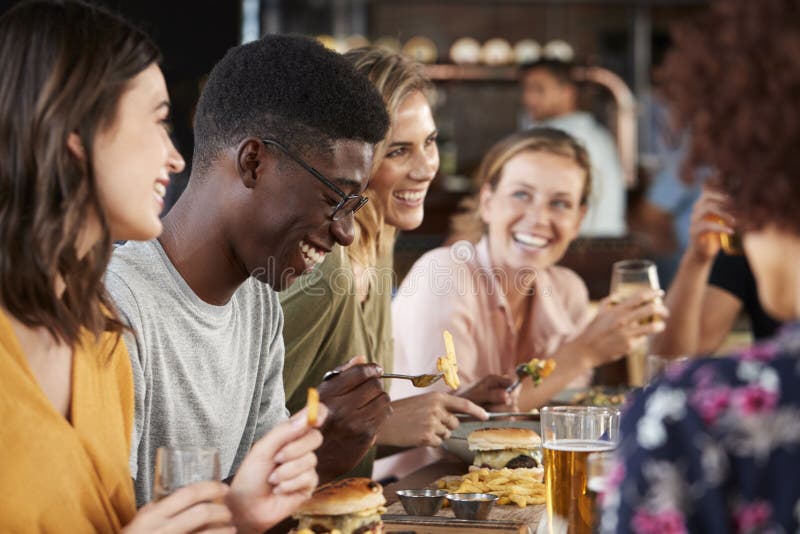 Group of Young Friends Meeting for Drinks and Food in Restaurant Stock ...
