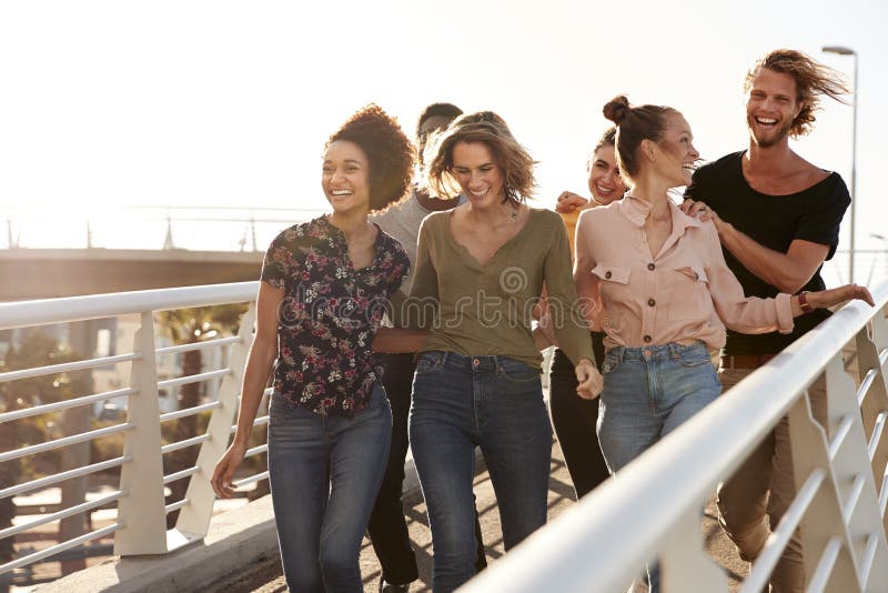 Group of Young Friends Outdoors Walking Along Gangway Together Stock ...
