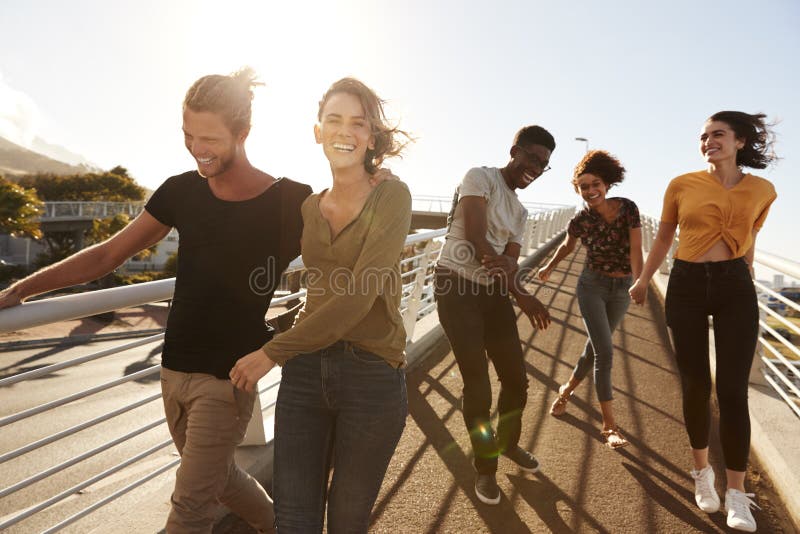 Group of Young Friends Outdoors Walking Along Gangway Together Stock ...