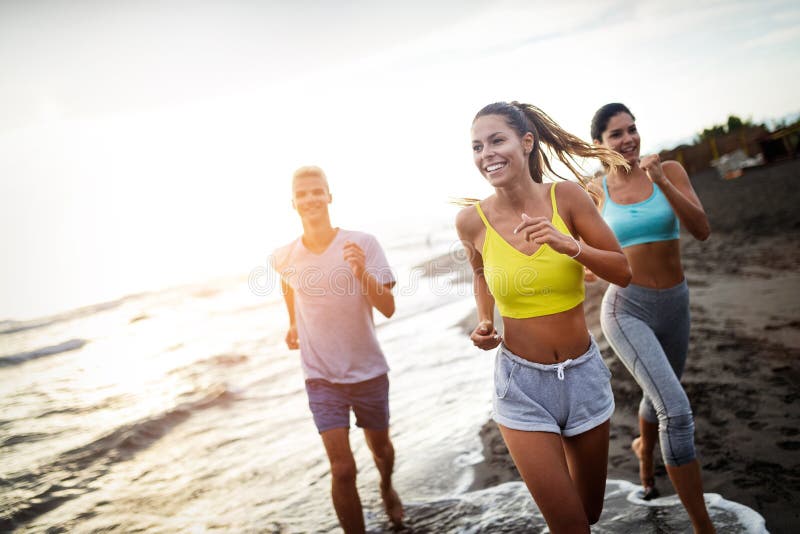 Group of Young Friends Running and Exercising on the Beach Stock Photo ...
