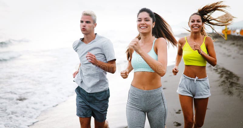 Group of Young Friends Running and Exercising on the Beach Stock Photo ...