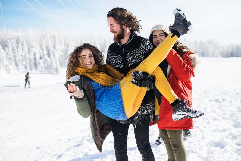 A Group of Young Friends on a Walk Outdoors in Snow in Winter Forest ...