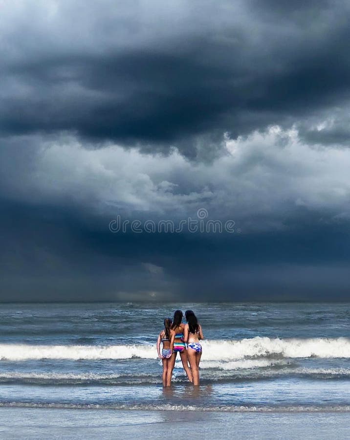 Group of Young Girls Standing in the Ocean before the Storm Stock Photo ...