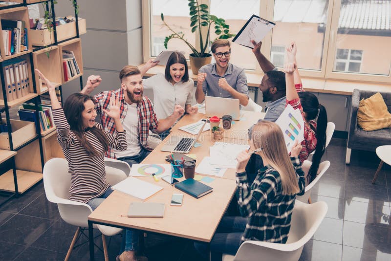 Group of Young Happy Managers Triumphing with Raised Hands Stock Photo ...