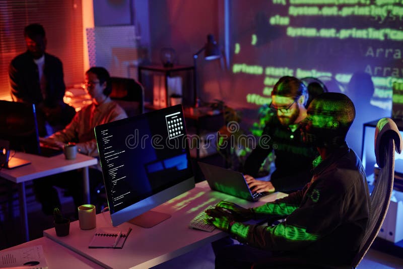 Group of Young Intercultural Coworkers Sitting by Desks in Front of ...