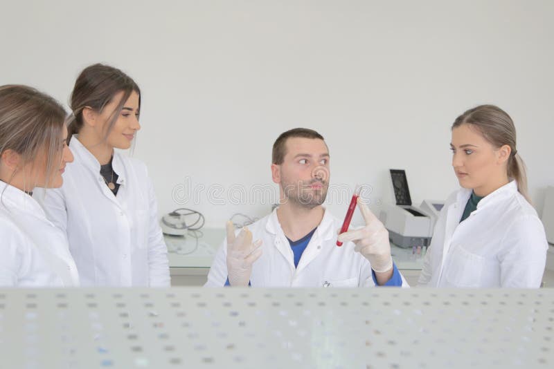 Group of Young Laboratory Scientists Working at Lab with Test Tubes and ...