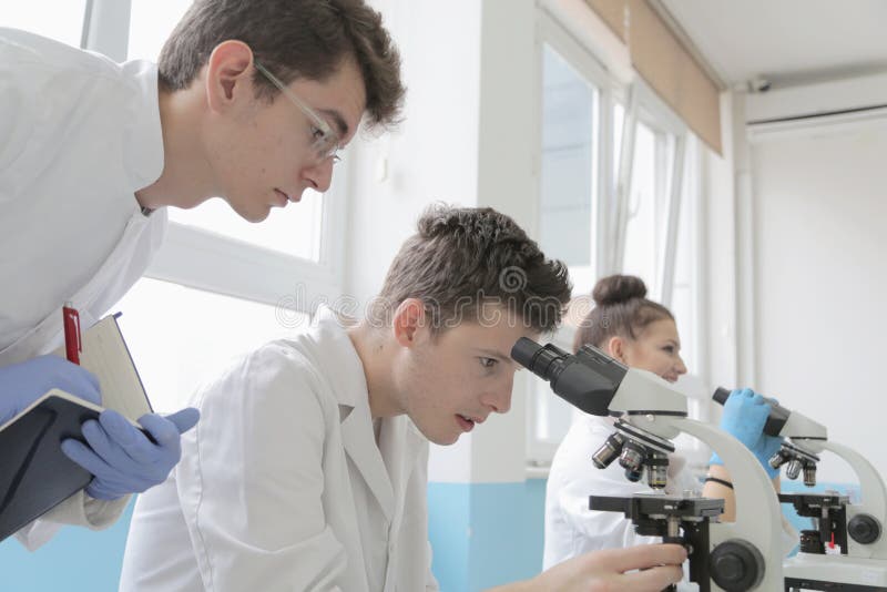 Group of Young Laboratory Scientists Working at Lab with Test Tubes and ...