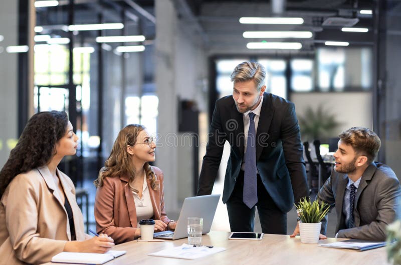 Group of Young Modern People in Suits Using Modern Technologies while ...