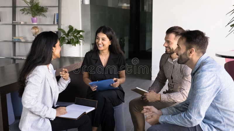 Group of Young Multiethnic Teammates Talking Seated in Workspace Stock ...