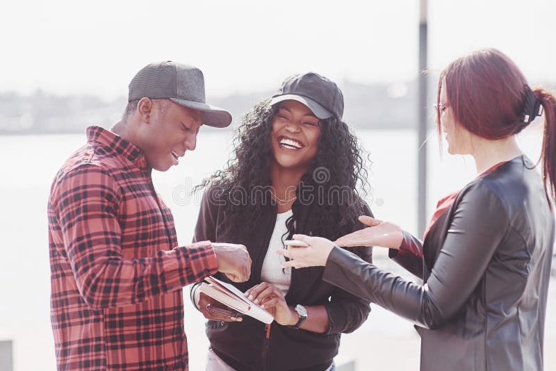 A Group of Young Multinational People with a Book, Students Studying in ...