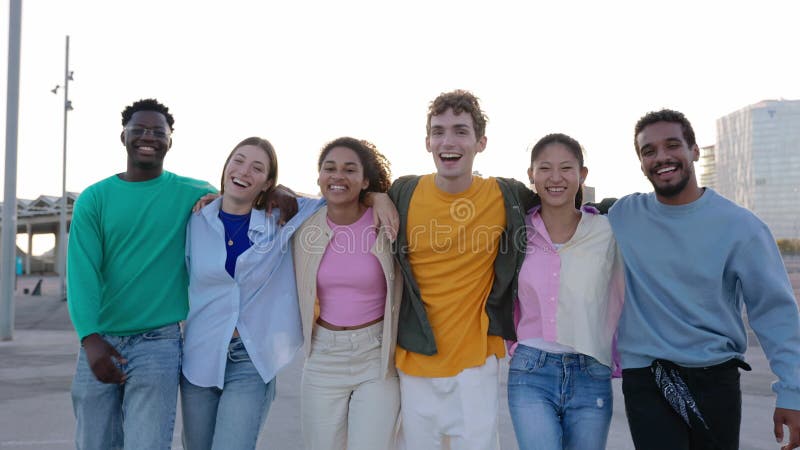 Group Of Young Multiracial Friends Hugging Each Other While Walking