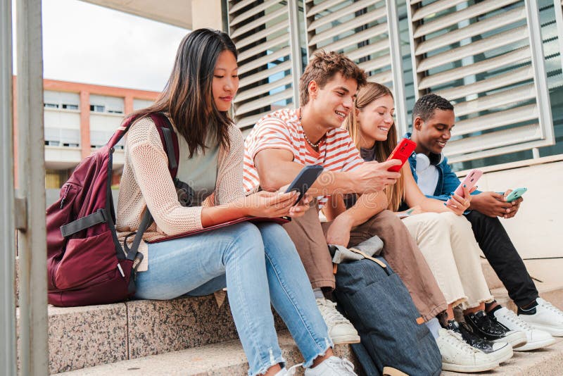 A Group of Young Multiracial Students Using a Cellphone To Check Their ...