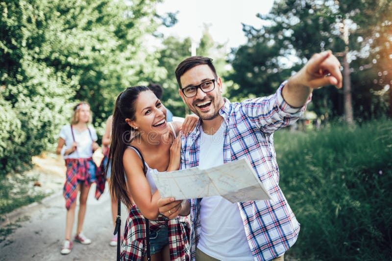 Young People with Backpacks Walking Together by the Road and Looking ...