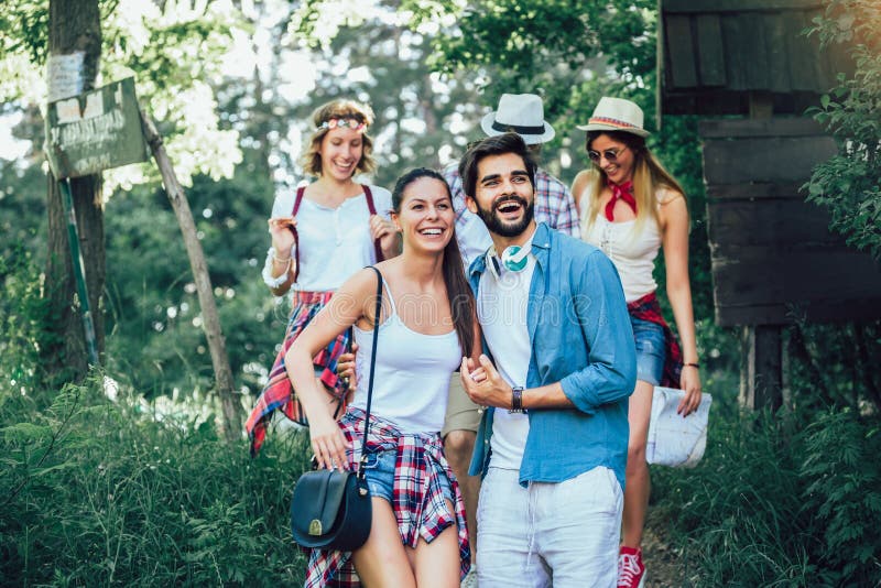 Young People with Backpacks Walking Together by the Road and Looking ...