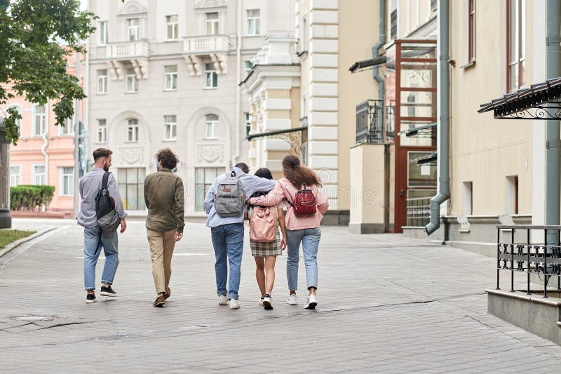 Group of Young People Chatting Merrily Walking Down the Street . Stock ...