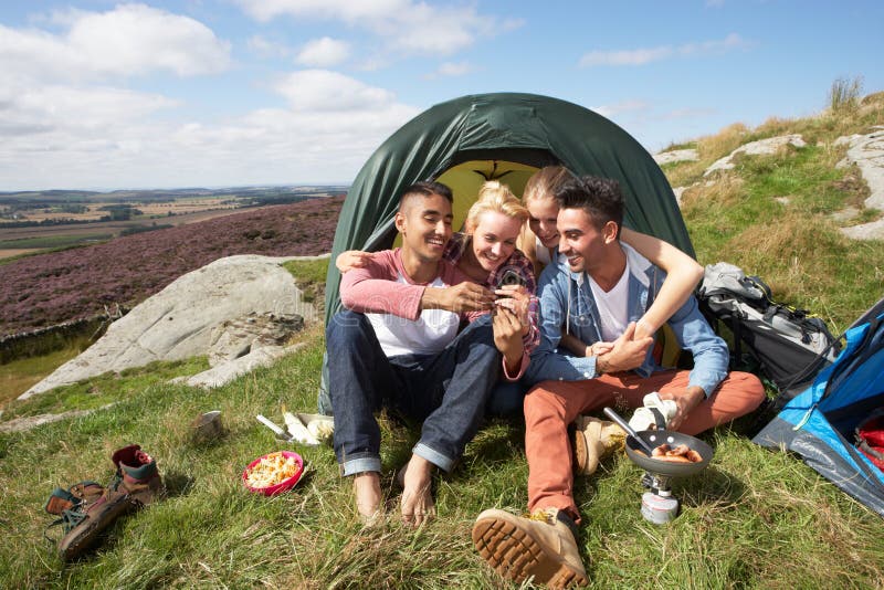 Group of Young People Checking Mobile Phone on Camping Trip Stock Photo ...