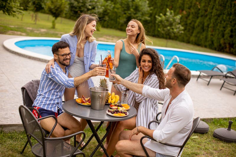 Group of Young People Cheering with Cider by the Pool in the Garden ...