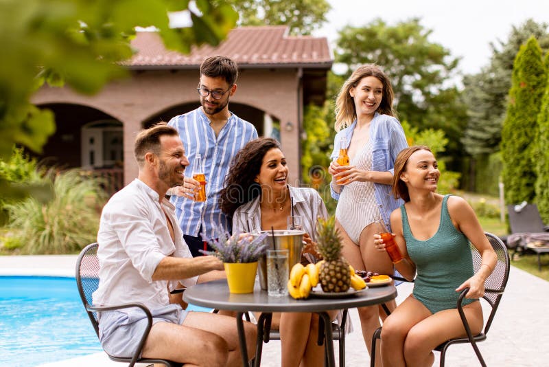 Group of Young People Cheering with Cider by the Pool in the Garden ...