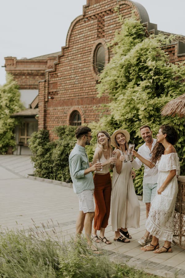 Group of Young People Cheering and Having Fun Outdoors with Drinks ...