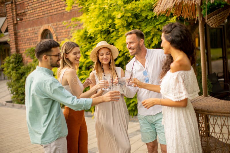 Group of Young People Cheering and Having Fun Outdoors with Drinks ...