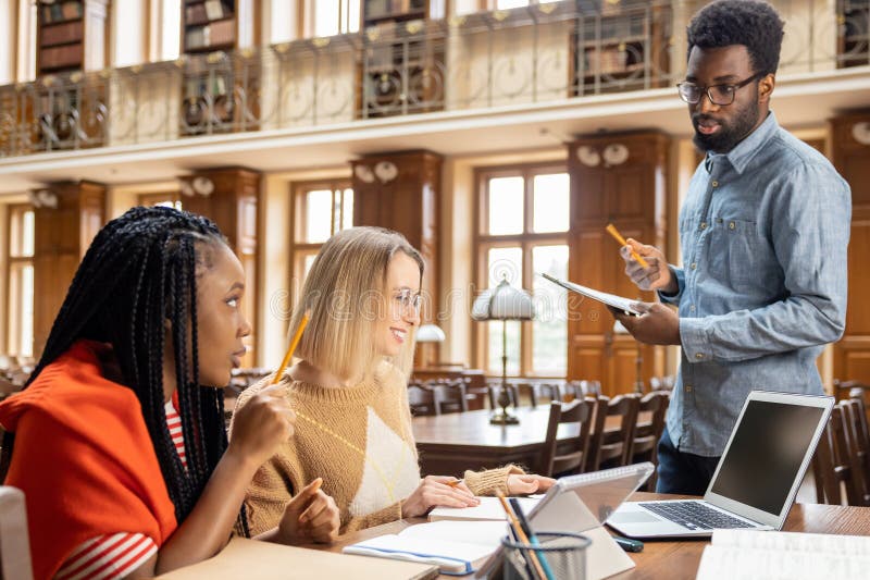 Group of Young People Discussing Something in the Library Stock Image ...