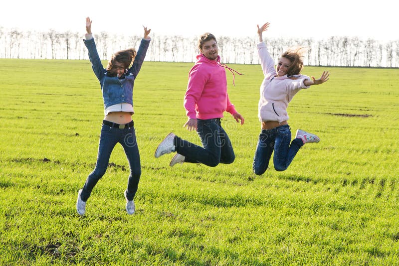Group of Young People on a Green Field Stock Image - Image of caucasian ...