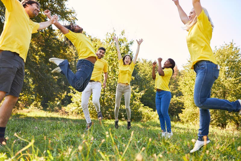 Group of Young People Jumping on Meadow for Team Building Stock Photo ...