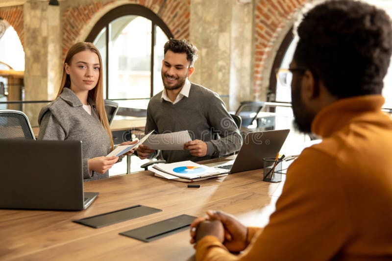 Group of Young People in the Office Discussing Project Details and ...