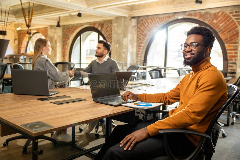 Group of Young People in the Office Discussing Project Details and ...