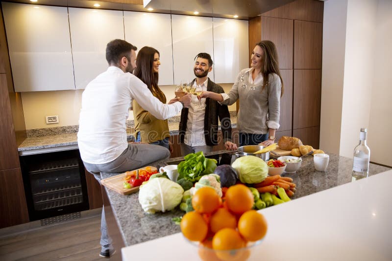 Group of Young People Preparing Meal, Drinking White Wine and Having a ...