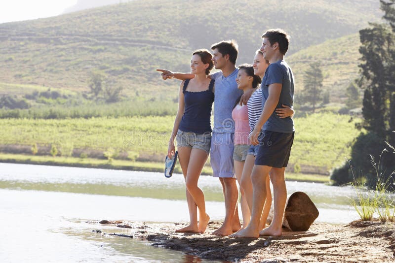 Group of Young People Standing at Shore of Lake Splashing Water Stock ...