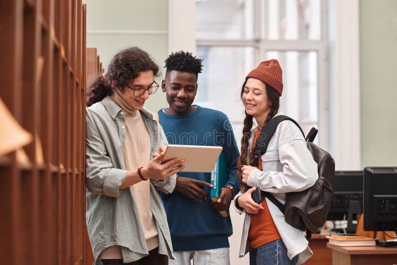Group of Young People Using Digital Tablet in Library Stock Photo ...