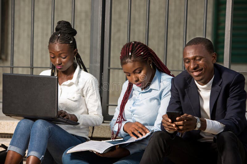 Group of Young People Using Smart Computers Sitting on Stairs Stock ...