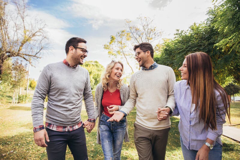 Group of Young People Walking through Park. Stock Image - Image of ...
